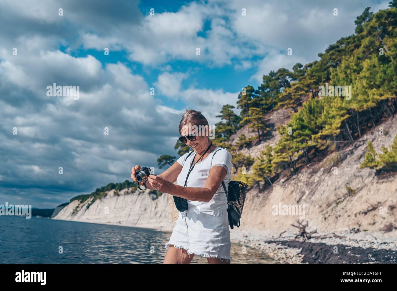 Elderly senior traveling backpacker mature woman tourist walking taking ...