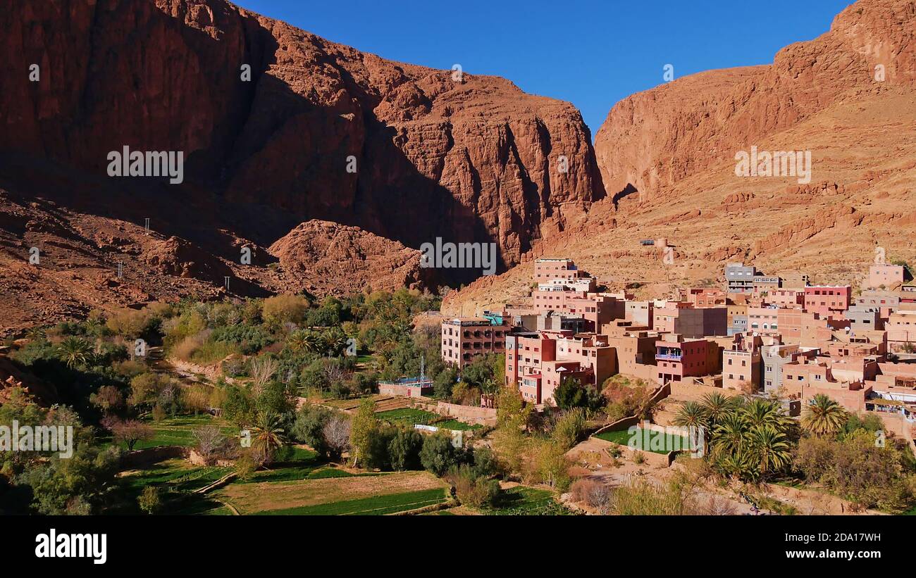 Small Berber village located in a green oasis valley with fields and ...