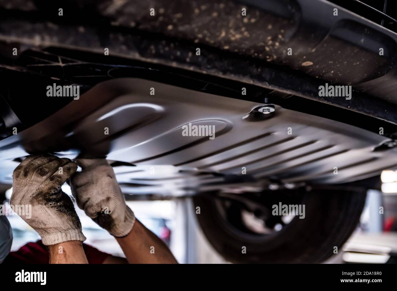 Mechanic installs underbody protection on a raised car Stock Photo - Alamy