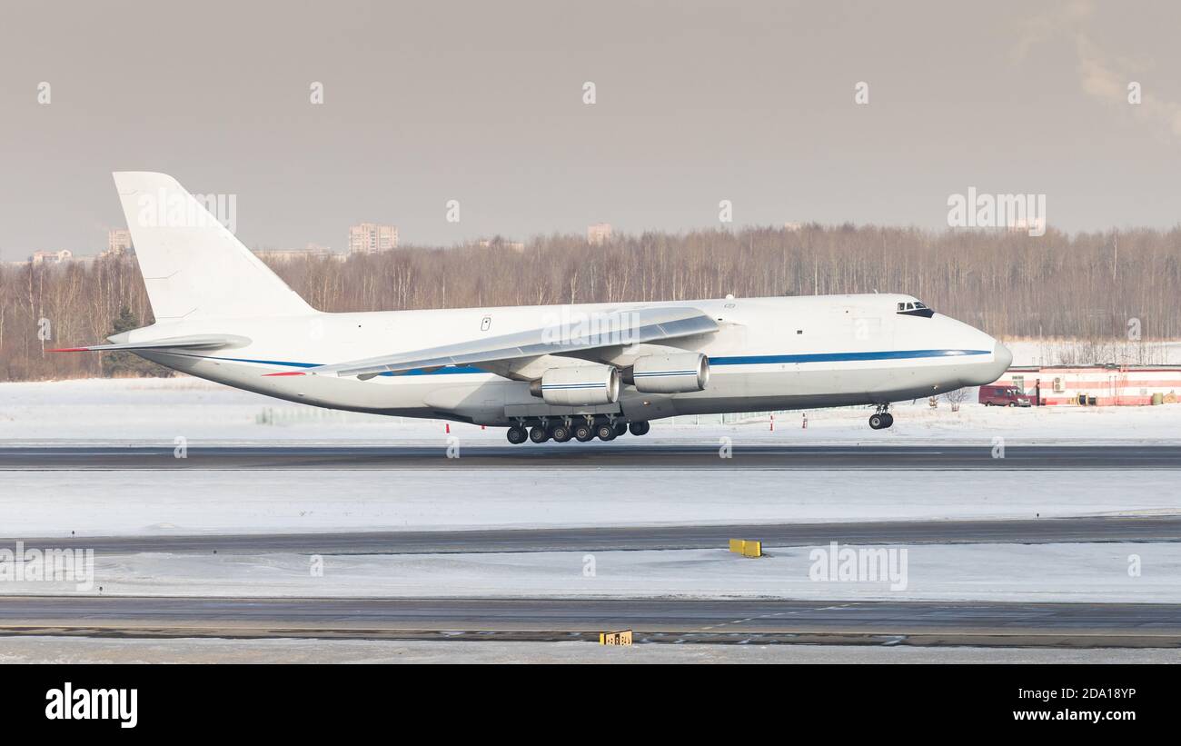 Huge white wide-body cargo airplane take off at sunny winter day, side ...