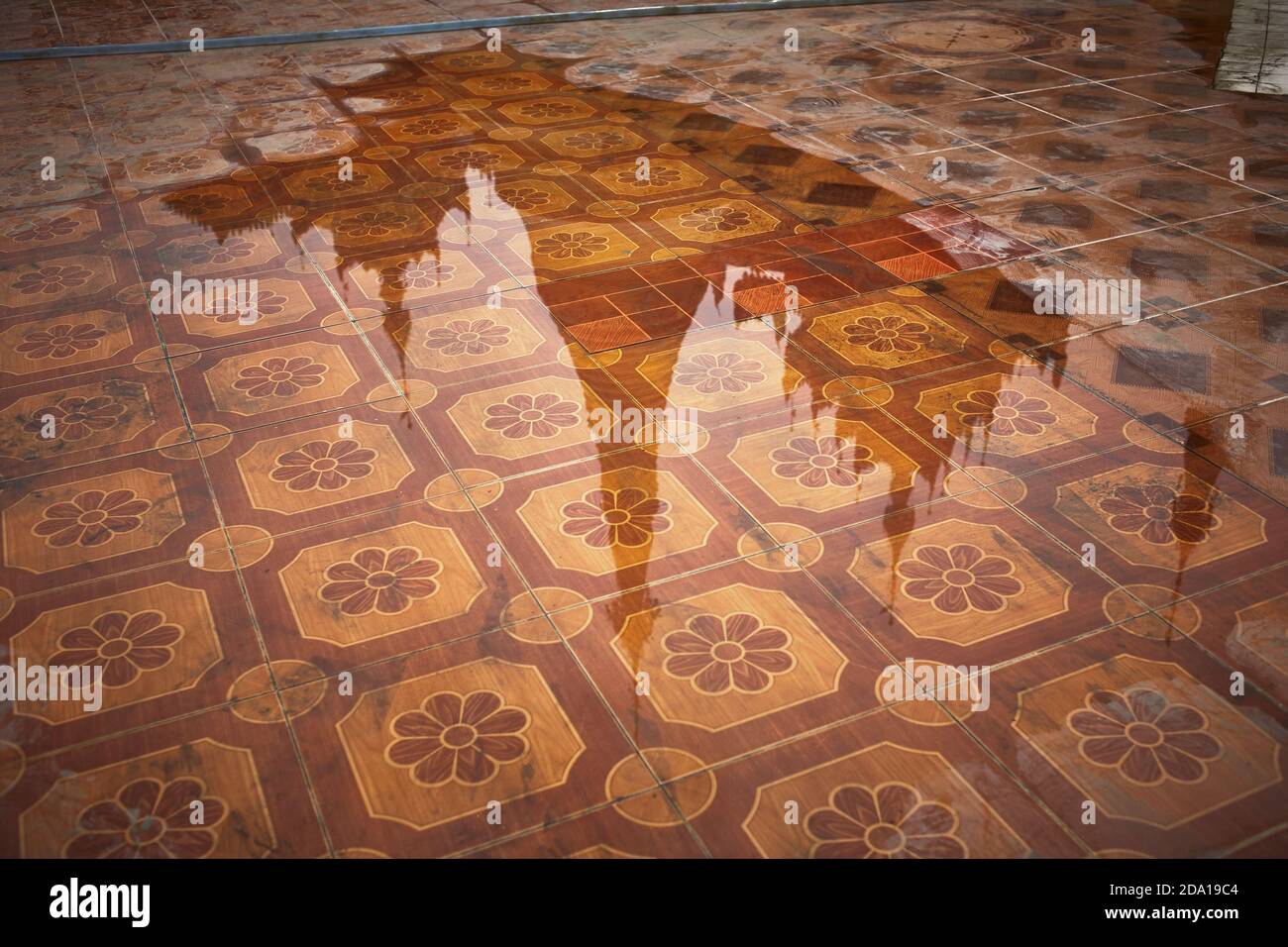 Myawaddy, Myanmar. April 2012. Reflection of a pagoda on the tiles of a ...