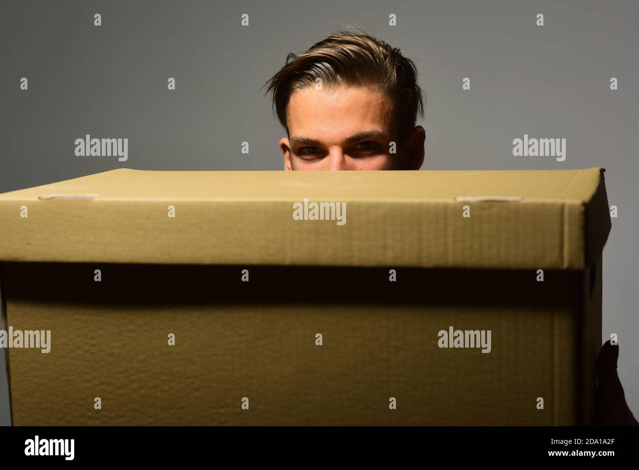 Delivery and moving concept. Man with messy hair isolated on dark grey ...