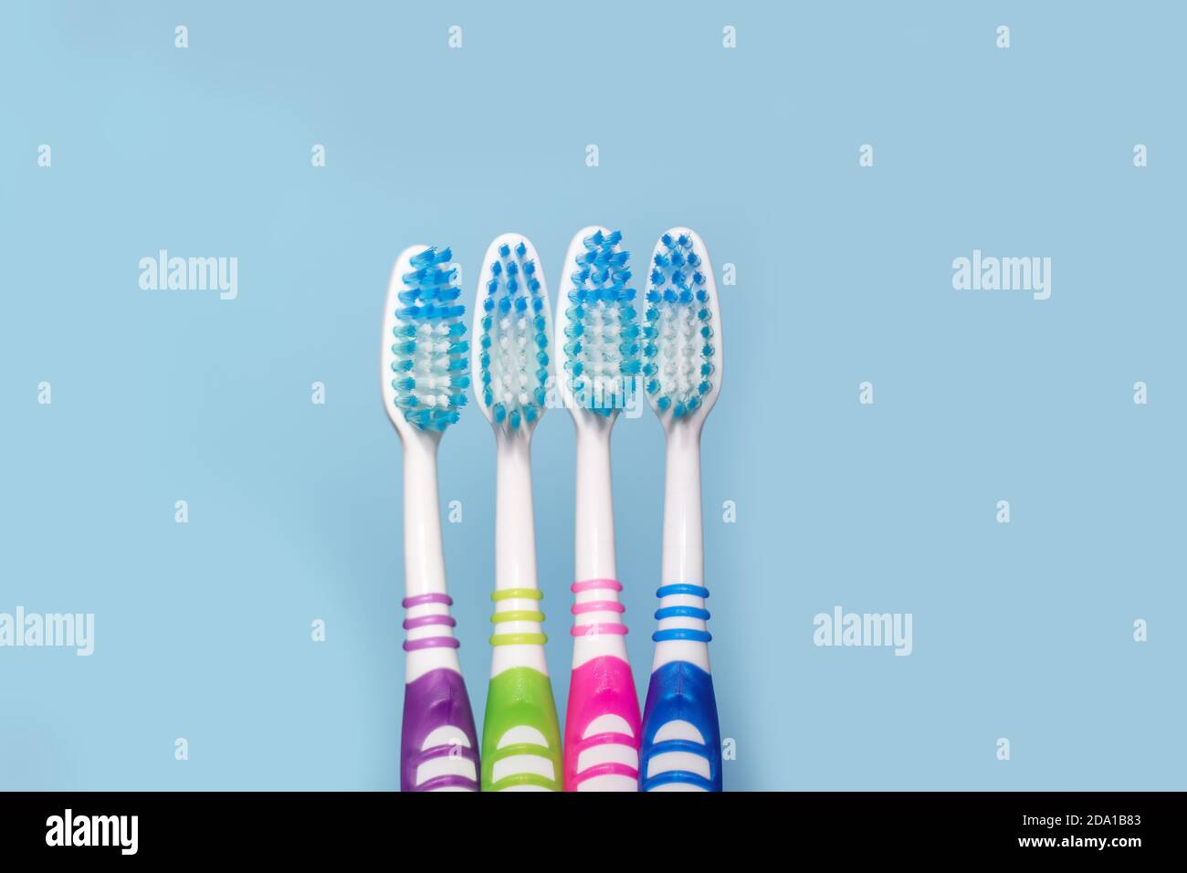 Photo of four multi-colored toothbrush, blue background with copy space ...