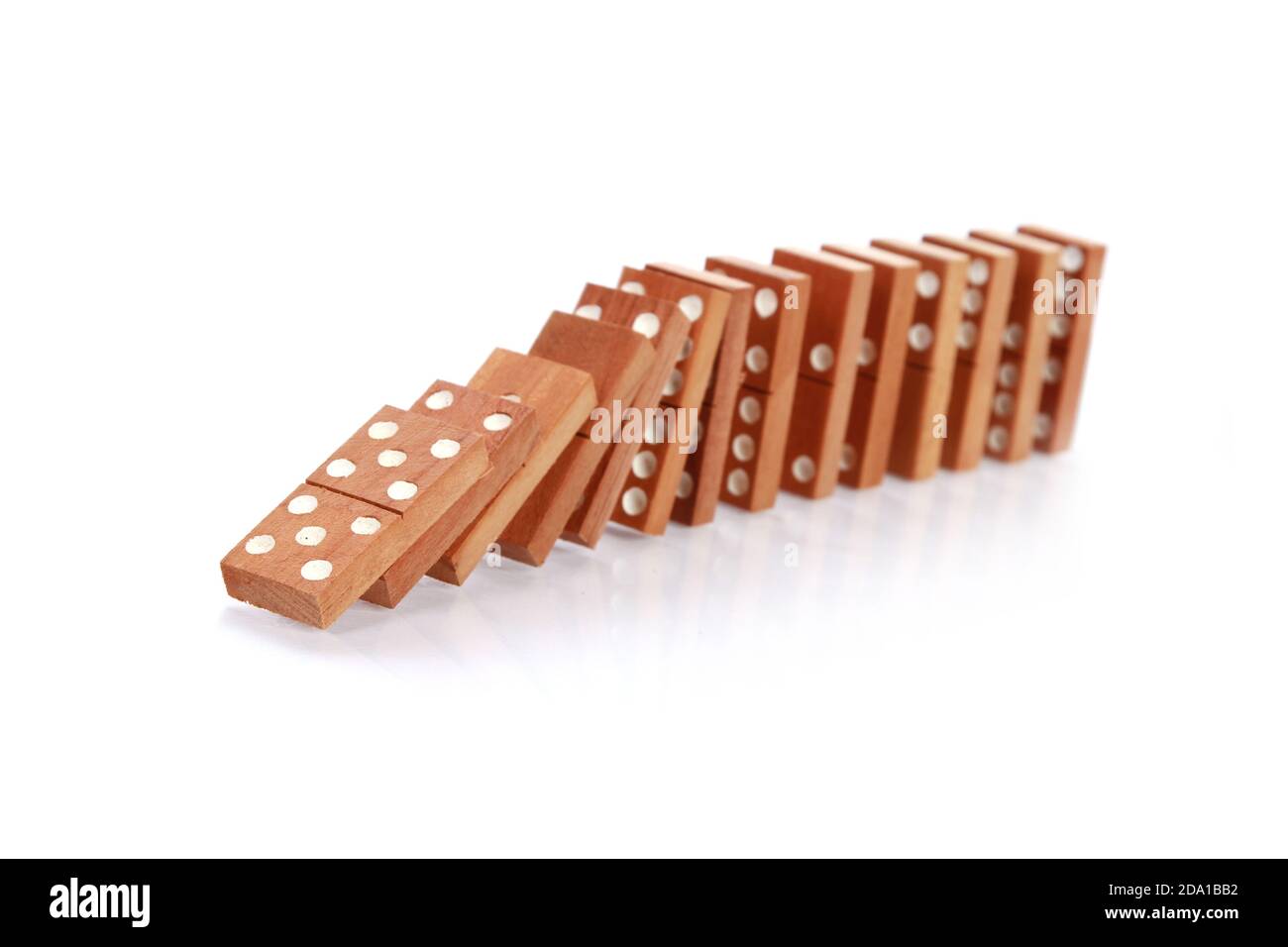 Closeup of the wooden dominoes falling on a white background Stock ...