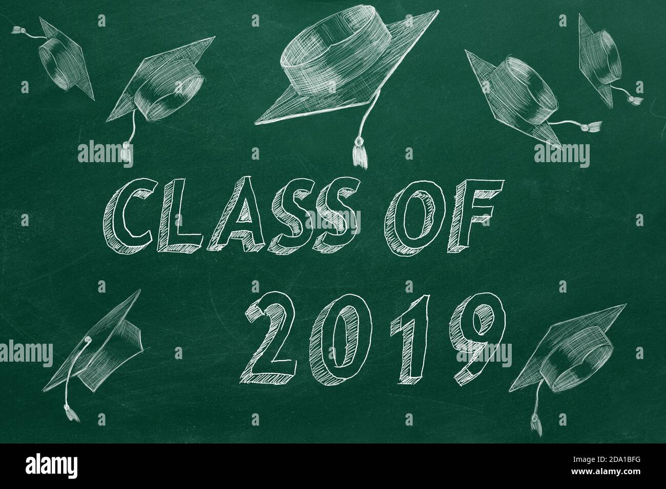Hand drawing "Class of 2019" and graduation caps on green chalkboard ...