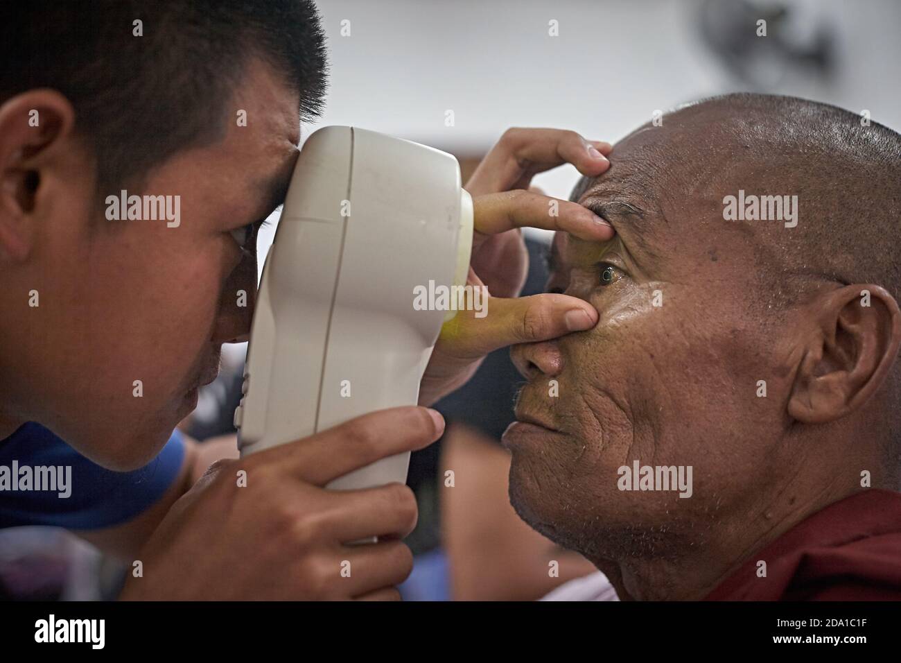 Mae Sot, Thailand. April 2012. A Buddhist monk performs an eye test at ...