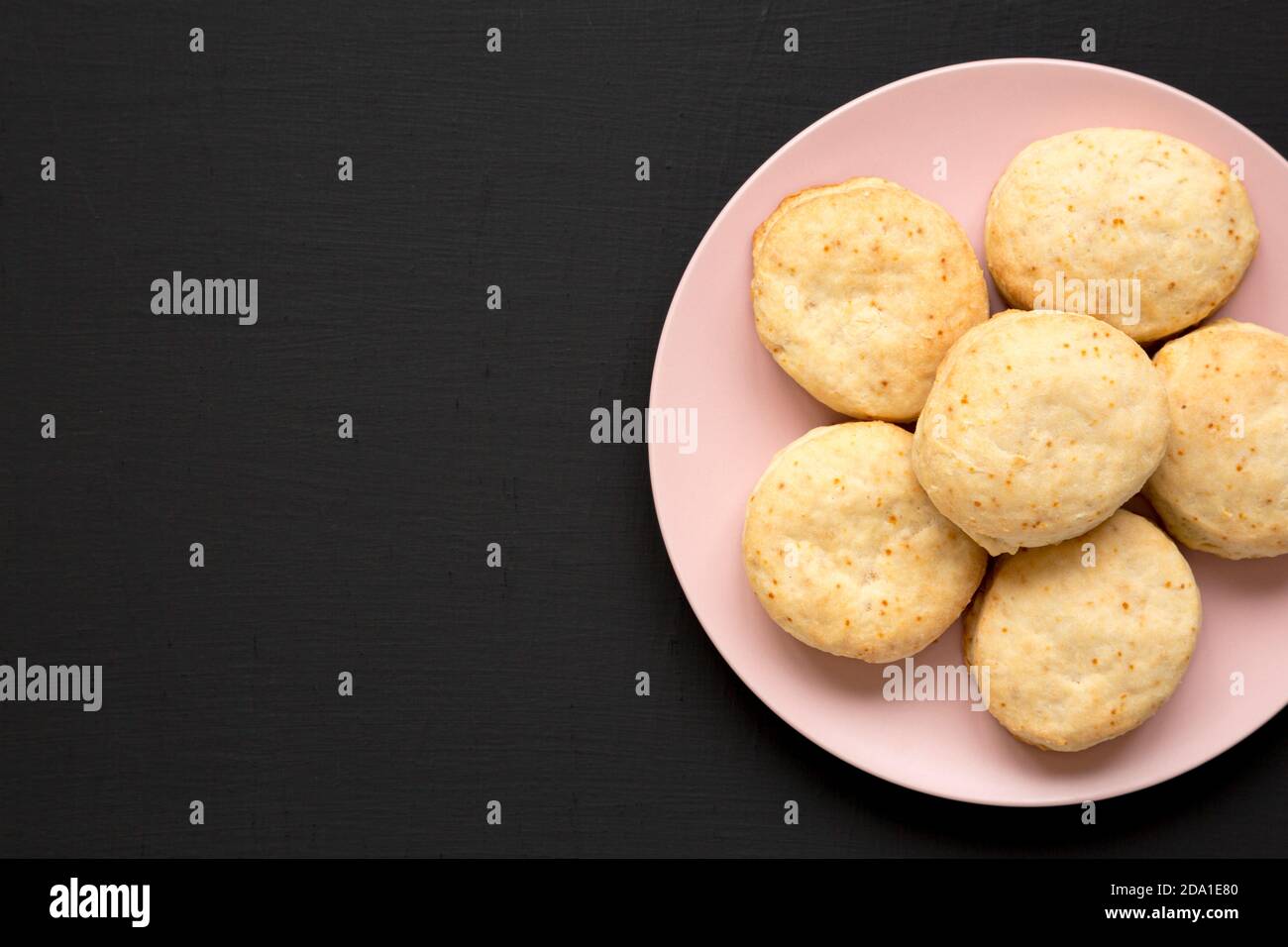 Homemade Flaky Buttermilk Biscuits on a pink plate on a black ...