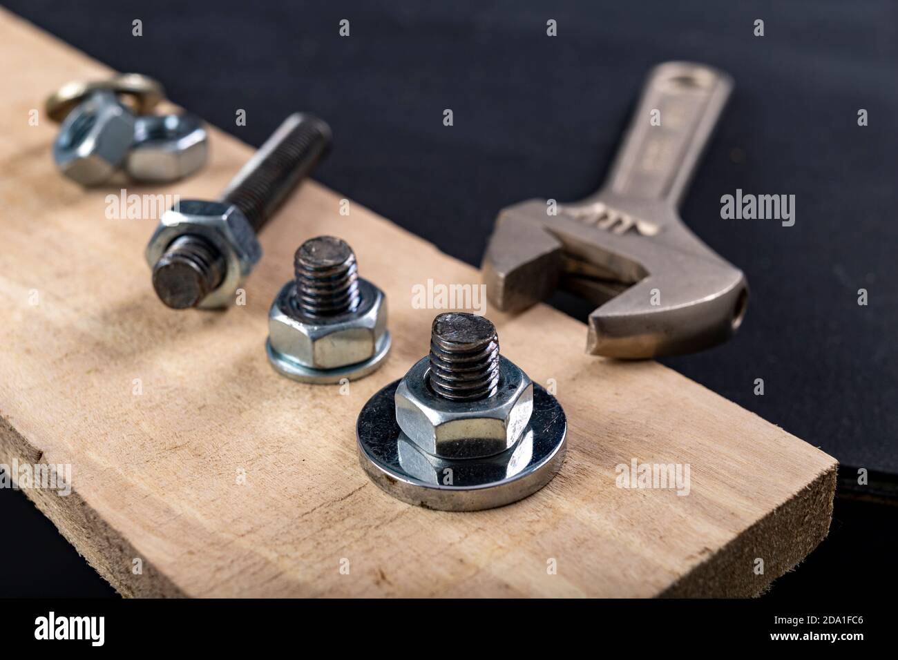 Metal bolts and nuts for joining wood. Tightening the screws with an ...