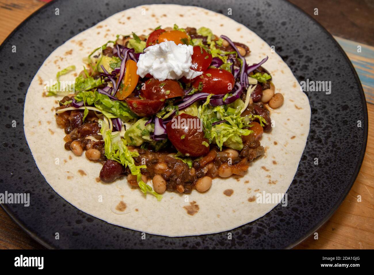 A plate of delicious smoky vegan chilli in a wrap Stock Photo - Alamy