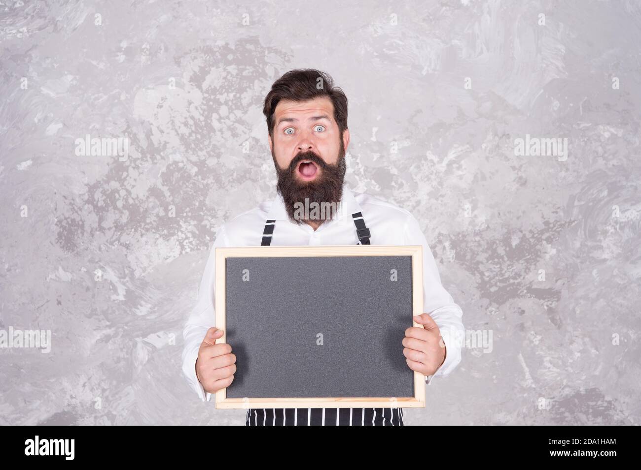 Caucasian hipster male cook with surprised face holding empty ...