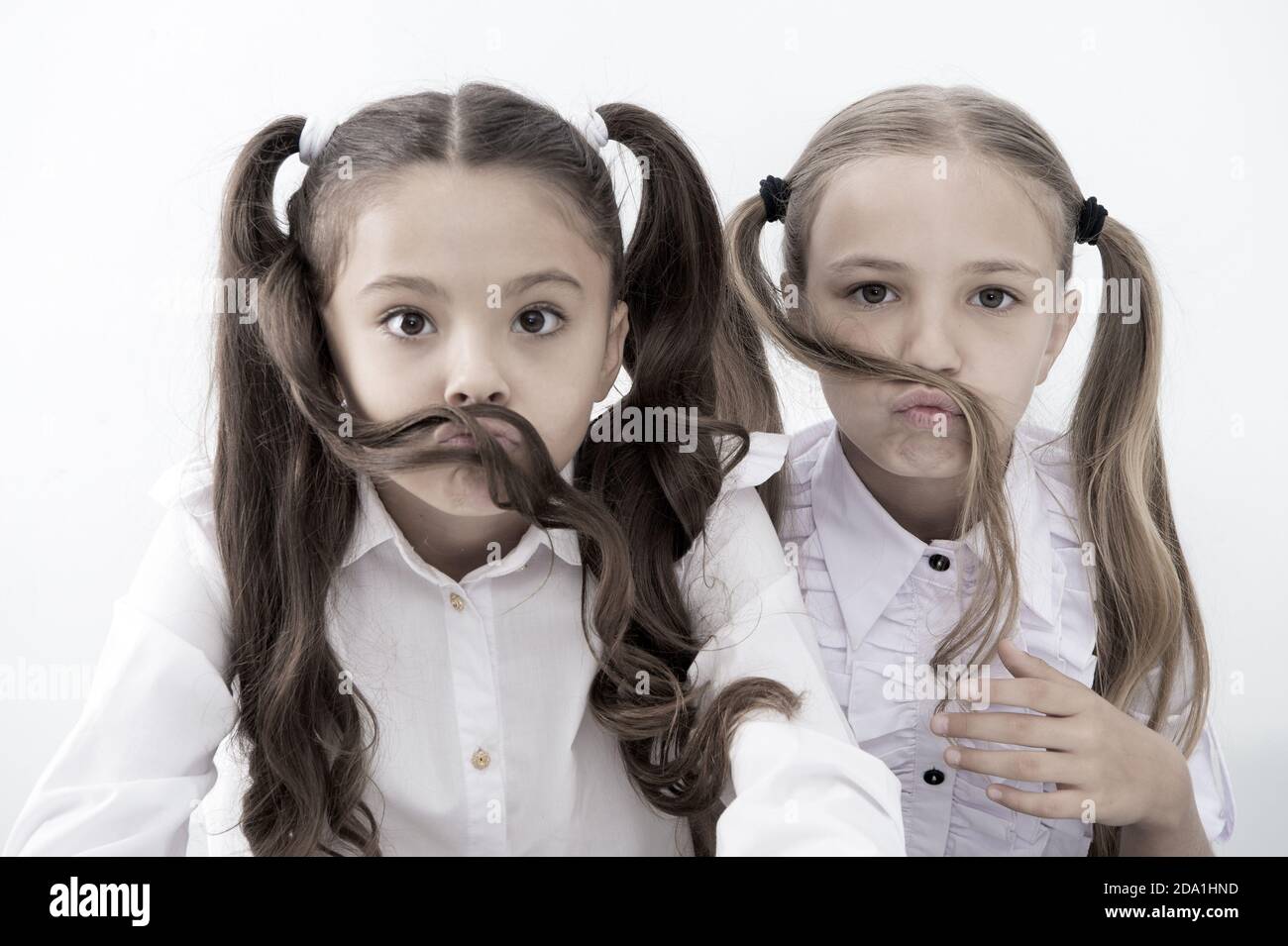 Little girls make mustache with long hair, hairstyle concept. little girls aving fun with ...