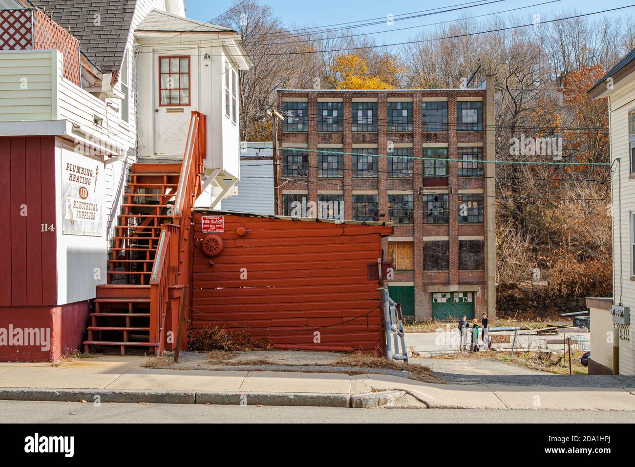 Three boys standing in the background near an old factory building in ...
