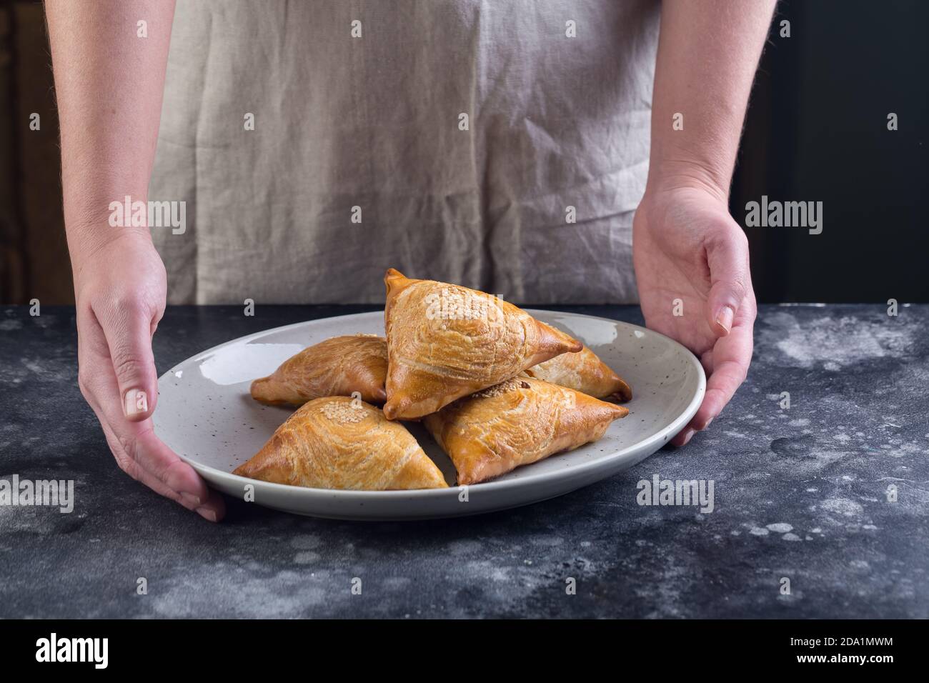 Traditional asian food. Samsa, samosa with meat. Girl is holding a ...