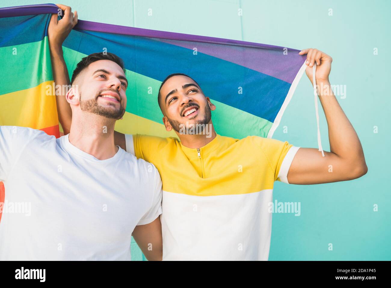Gay couple embracing and showing their love with rainbow flag Stock ...