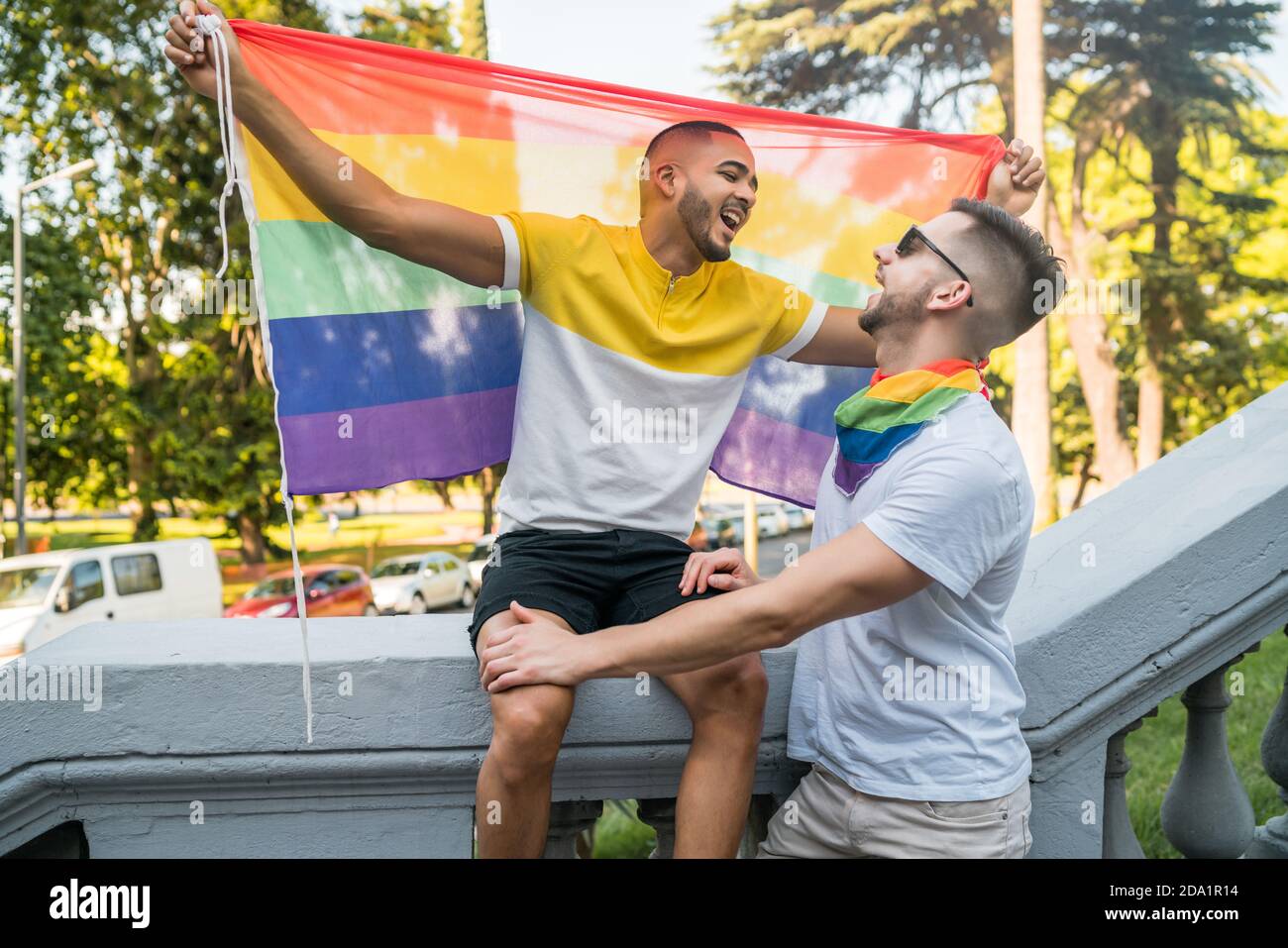 Gay couple embracing and showing their love with rainbow flag Stock ...