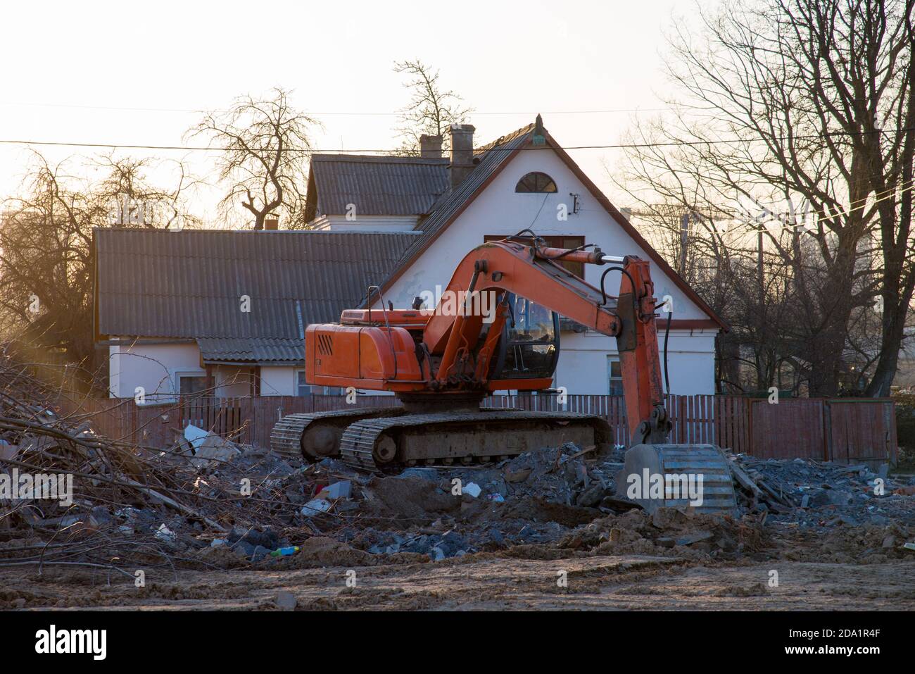 Excavator demolishes an old wooden house in the village for new ...