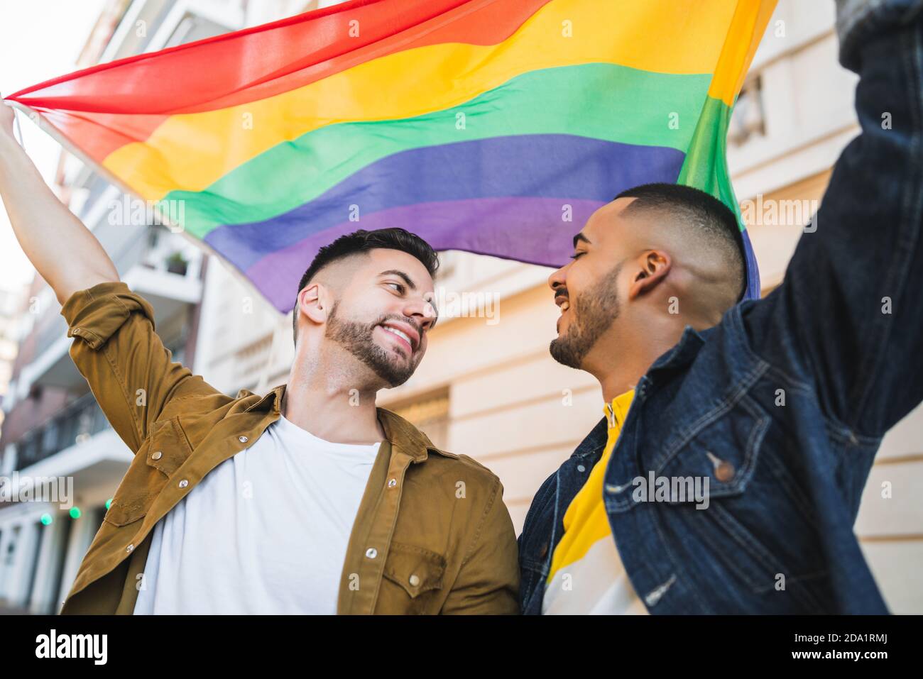 Gay Couple Embracing And Showing Their Love With Rainbow Flag Stock