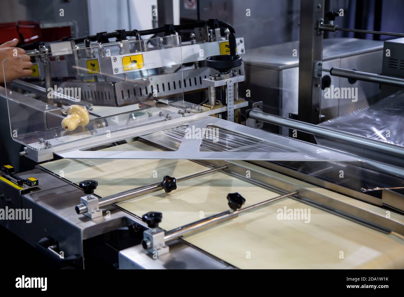 Shrink film wraping machine in food industry Stock Photo - Alamy