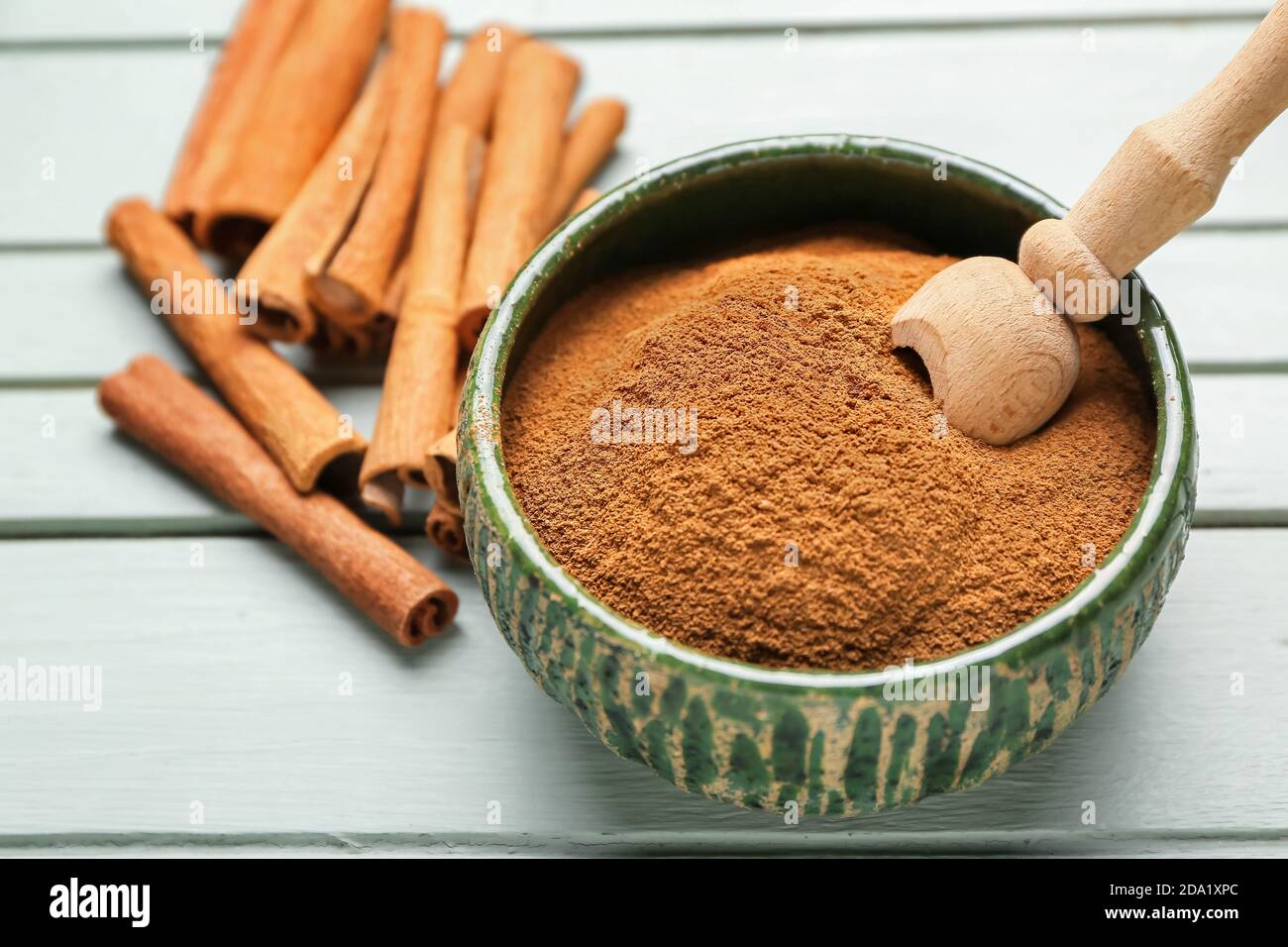 Bowl with cinnamon powder and sticks on wooden background Stock Photo ...
