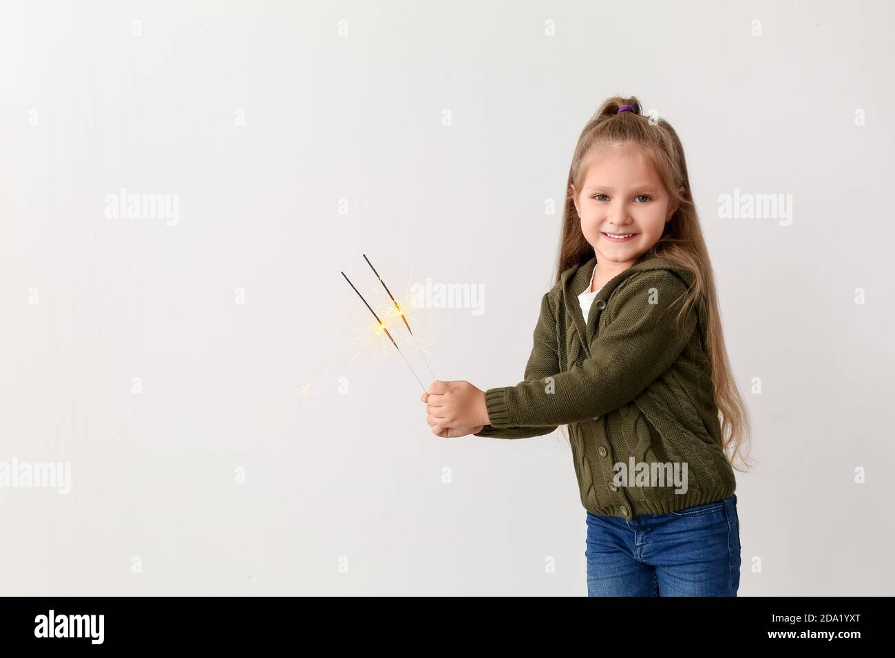 Cute little girl with Christmas sparklers on light background Stock ...