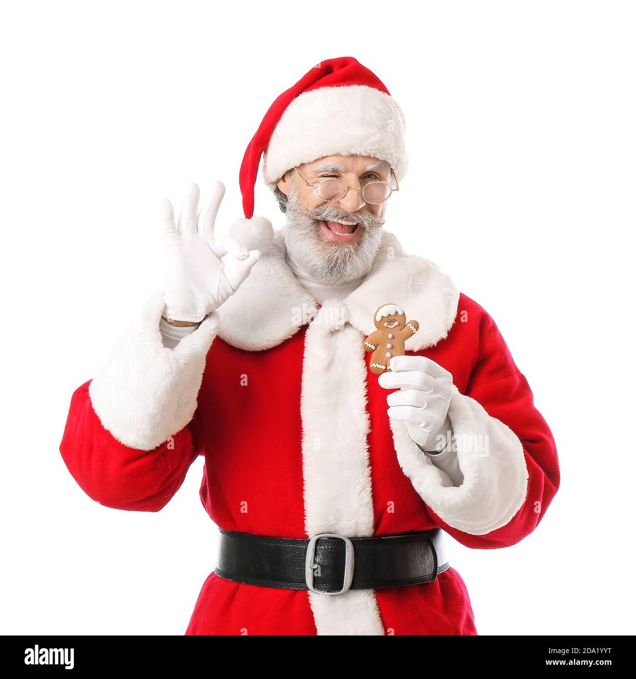 Santa Claus with tasty gingerbread cookie showing OK on white ...