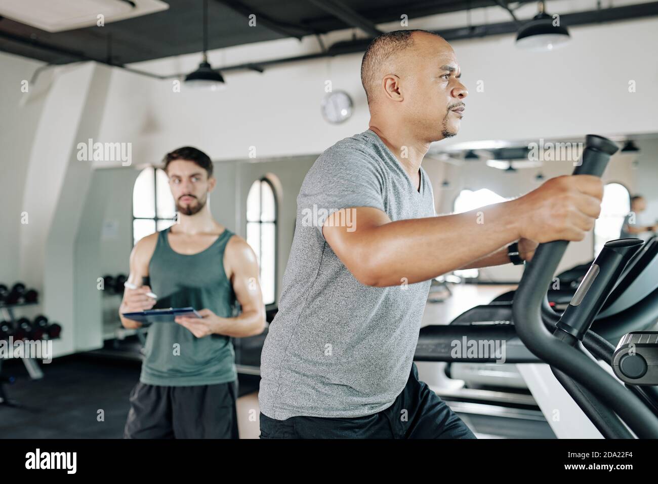 Walking in elliptical machine Stock Photo - Alamy