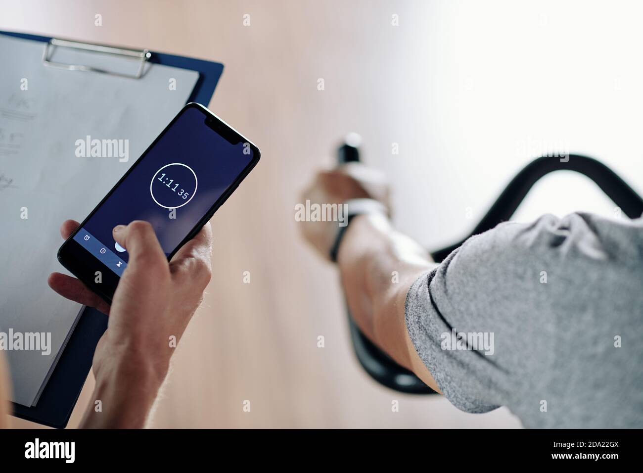 Fitness trainer checking stopwatch Stock Photo - Alamy