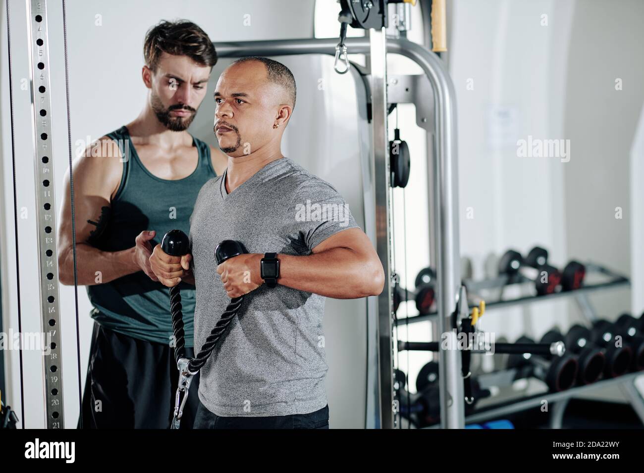 Man doing standing cable lift exercise Stock Photo - Alamy