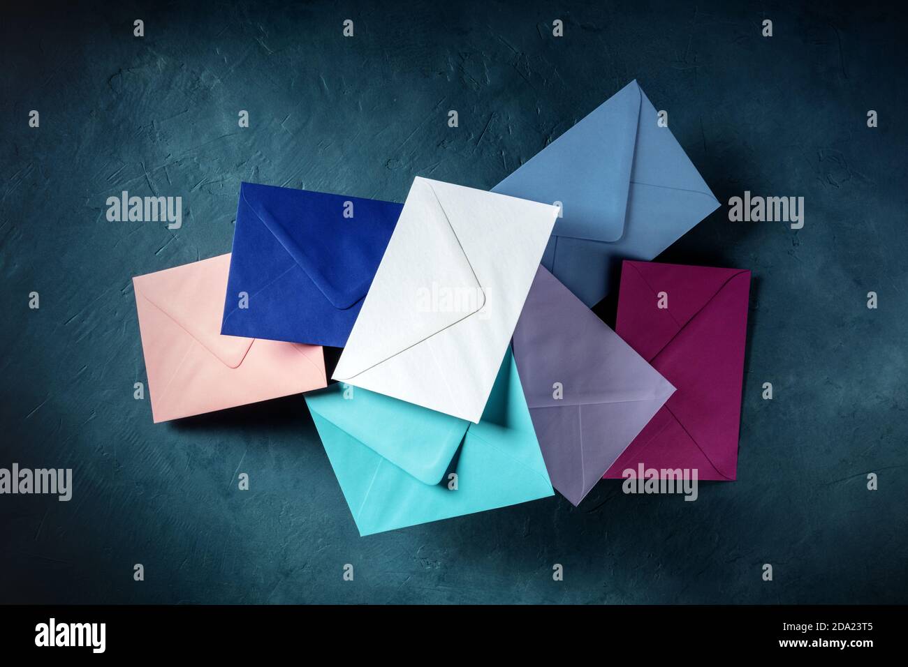 Colourful envelopes flying in the air over a dark blue background, the ...