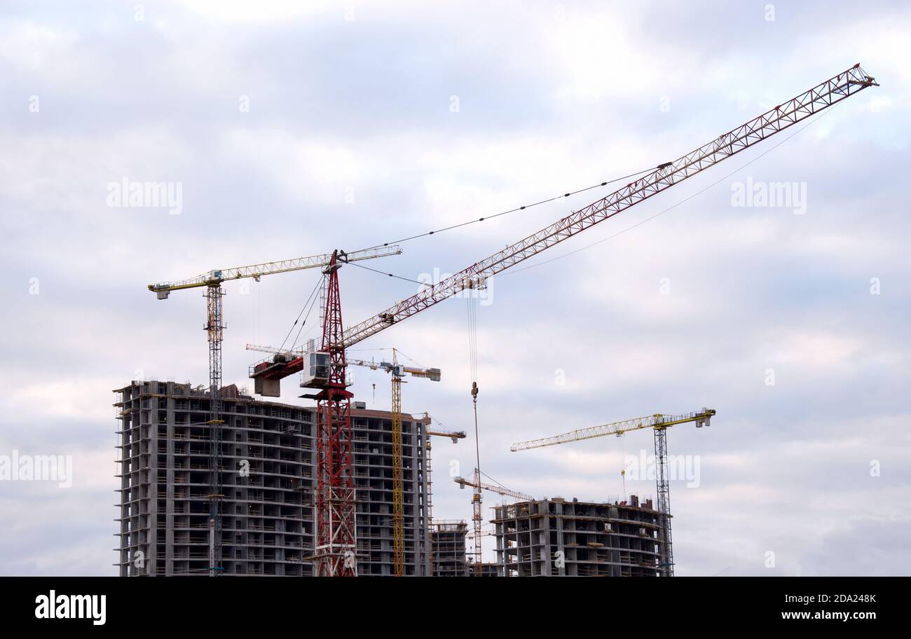 Tower cranes at large scale construction site against blue sky ...