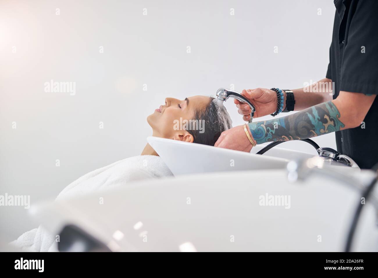 Unknown stylist and a model in a robe with the closed eyes Stock Photo ...