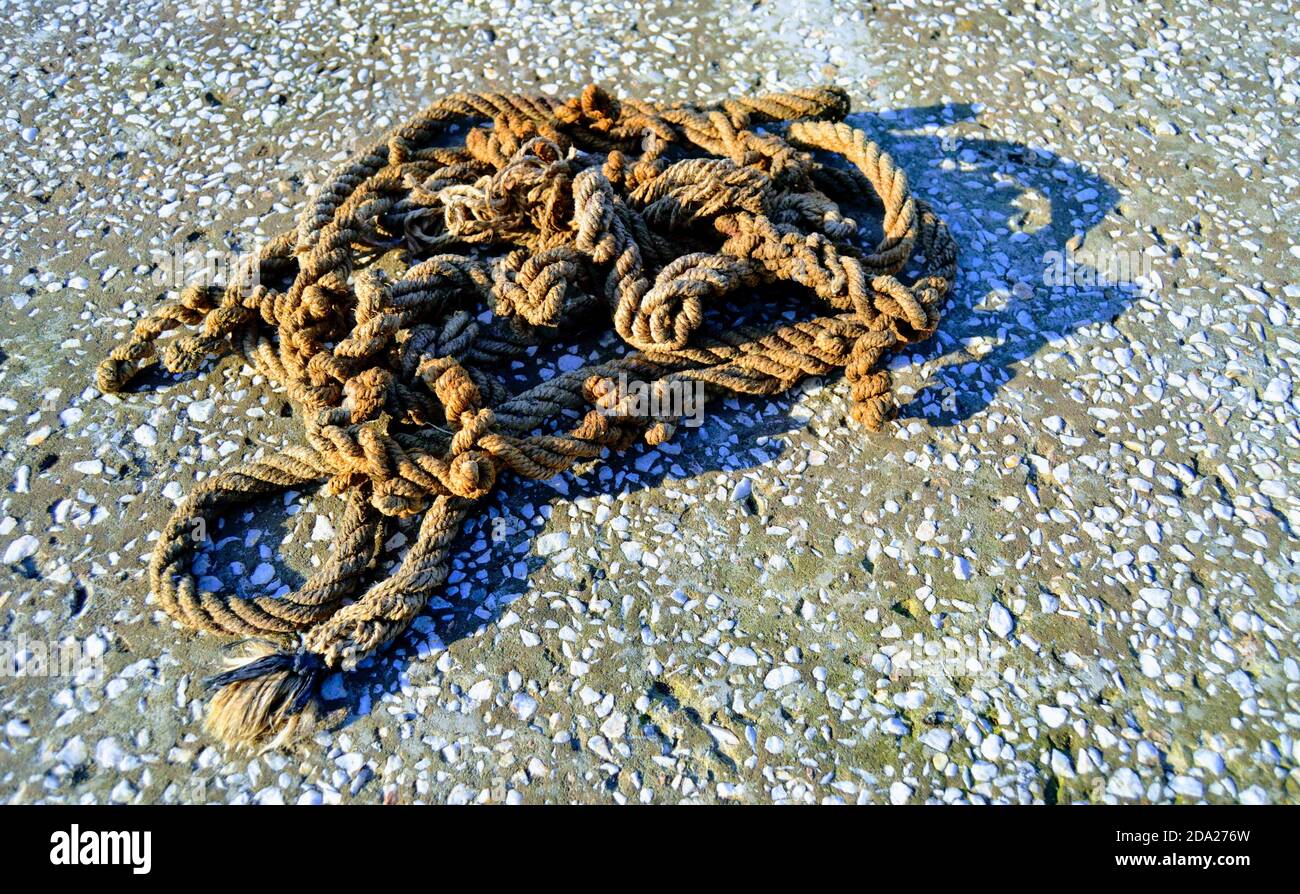 Rope and shadows during sunny day.. An old and frayed rope standing in ...