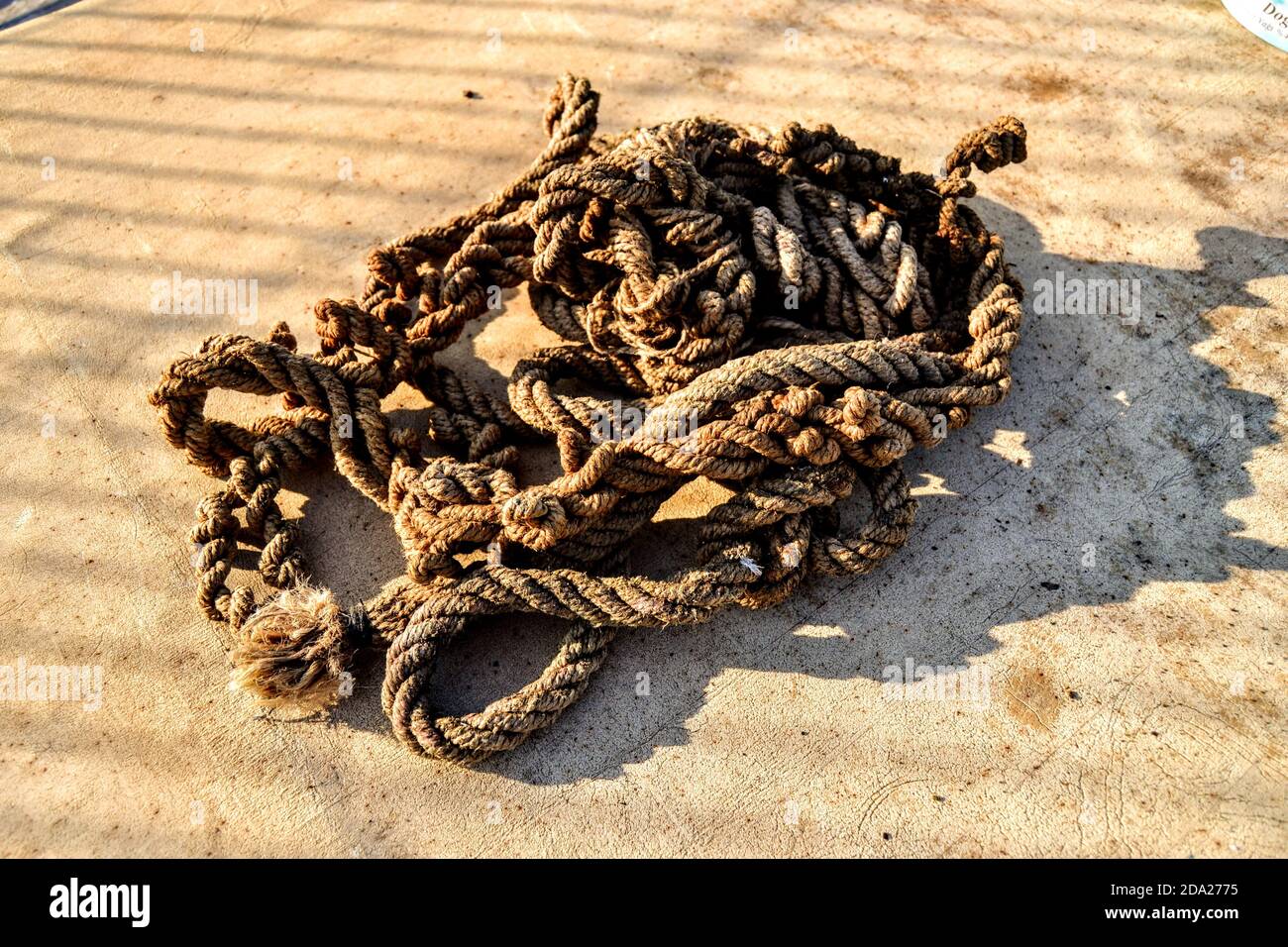 Rope and shadows during sunny day.. An old and frayed rope standing in ...
