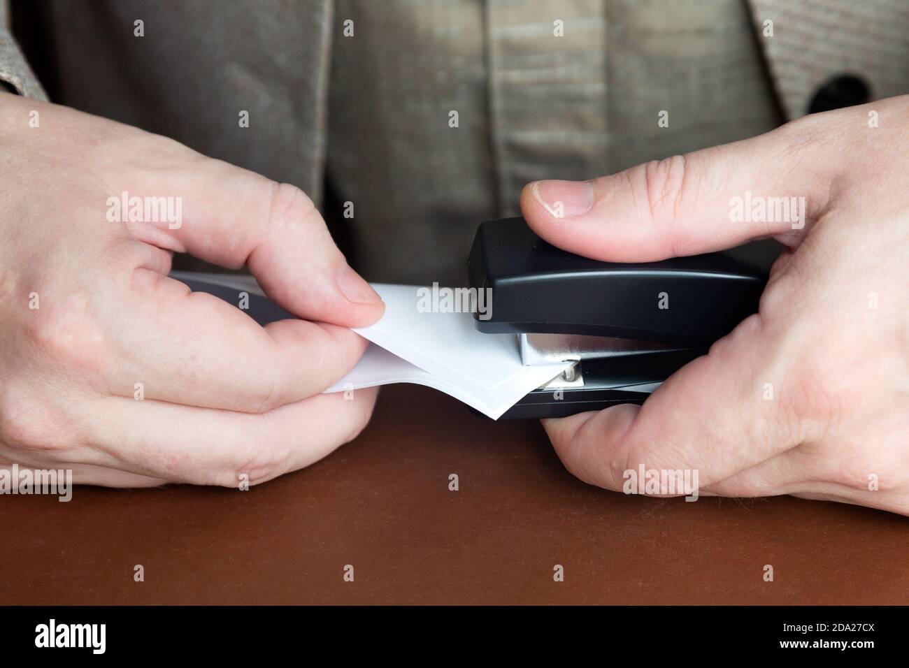 Worker staples sheets of paper. Close-up, concept Stock Photo - Alamy