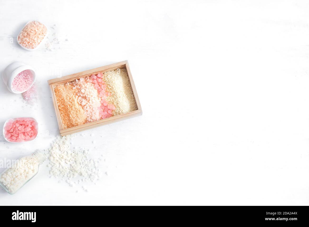 Multicolored sea salt in a box on a white background top view, flat lay ...