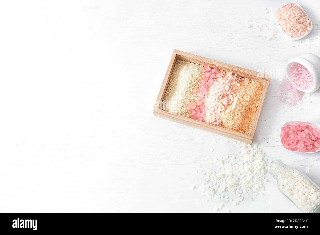 Multicolored sea salt in a box on a white background top view, flat lay ...