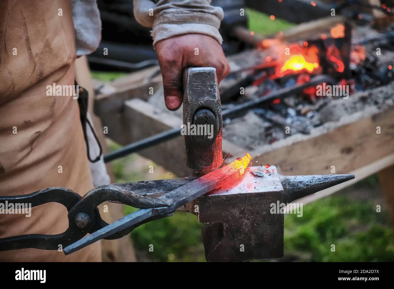 Twisting a red-hot billet is clamped in the grip. Blacksmith twists a ...