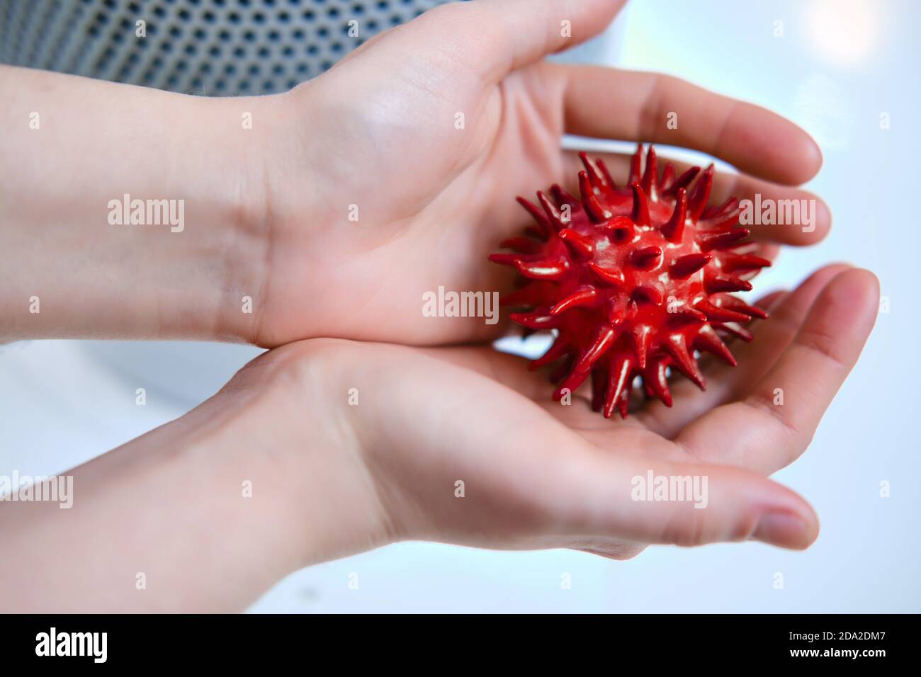 Hands holding a coronavirus molecule, concept of touching the virus and ...