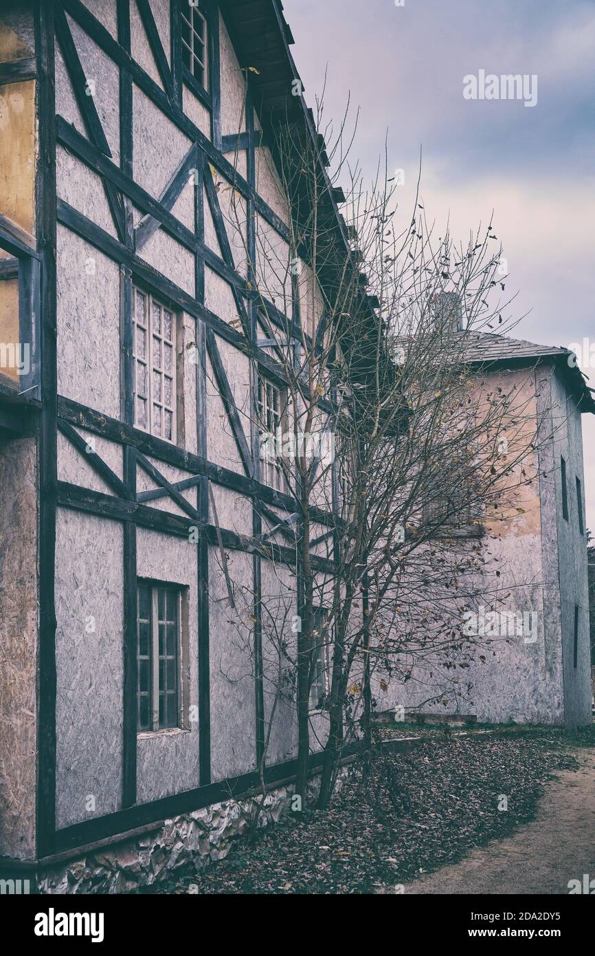 Old buildings in the autumn landscape of an empty street with growing ...