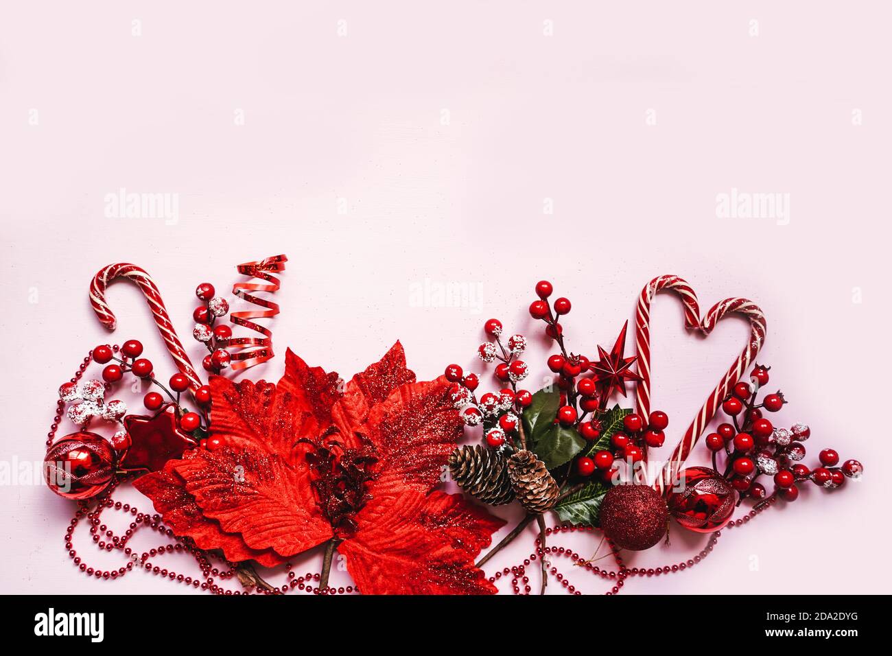 Collection of red Christmas objects as border viewed from above on pink ...