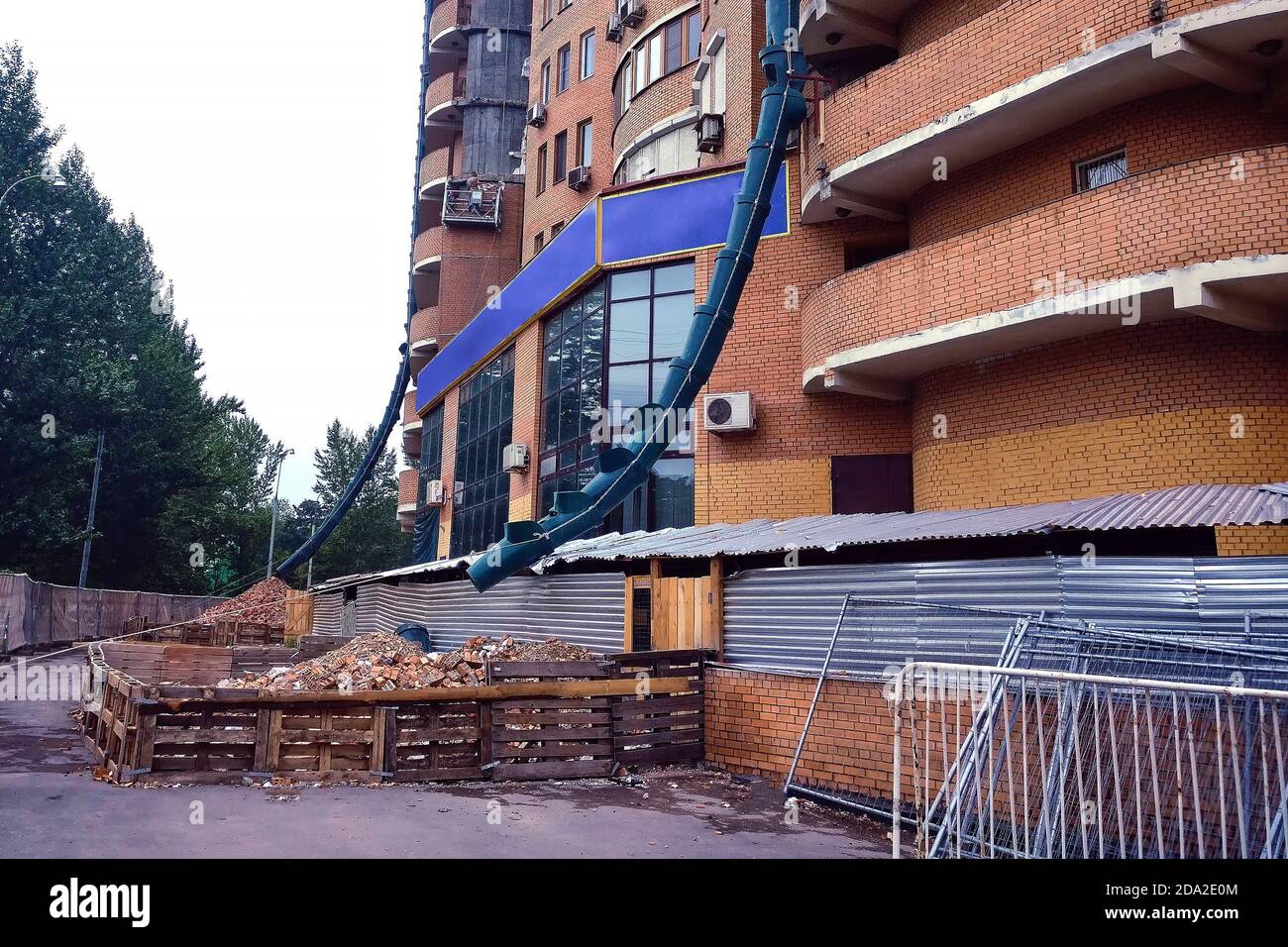 Pipe for dumping construction debris. Repair of the facade of a ...