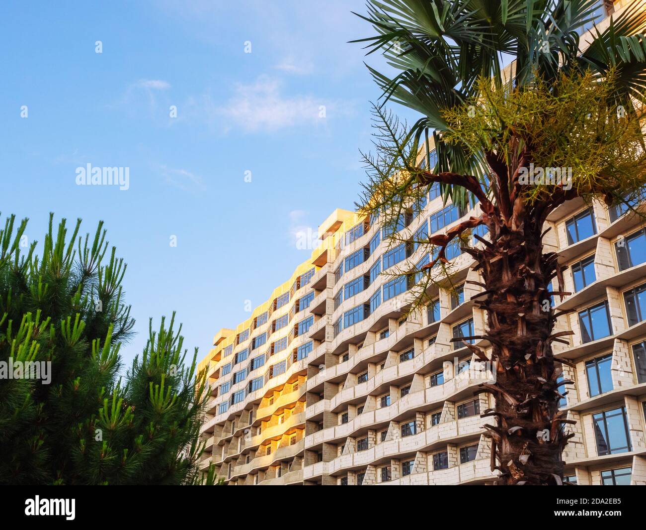 Large tenement unfinished new building on a blue sky background with ...