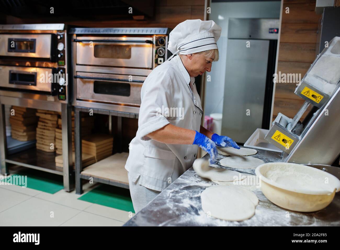 Female chef preparing pizza in restaurant kitchen Stock Photo - Alamy
