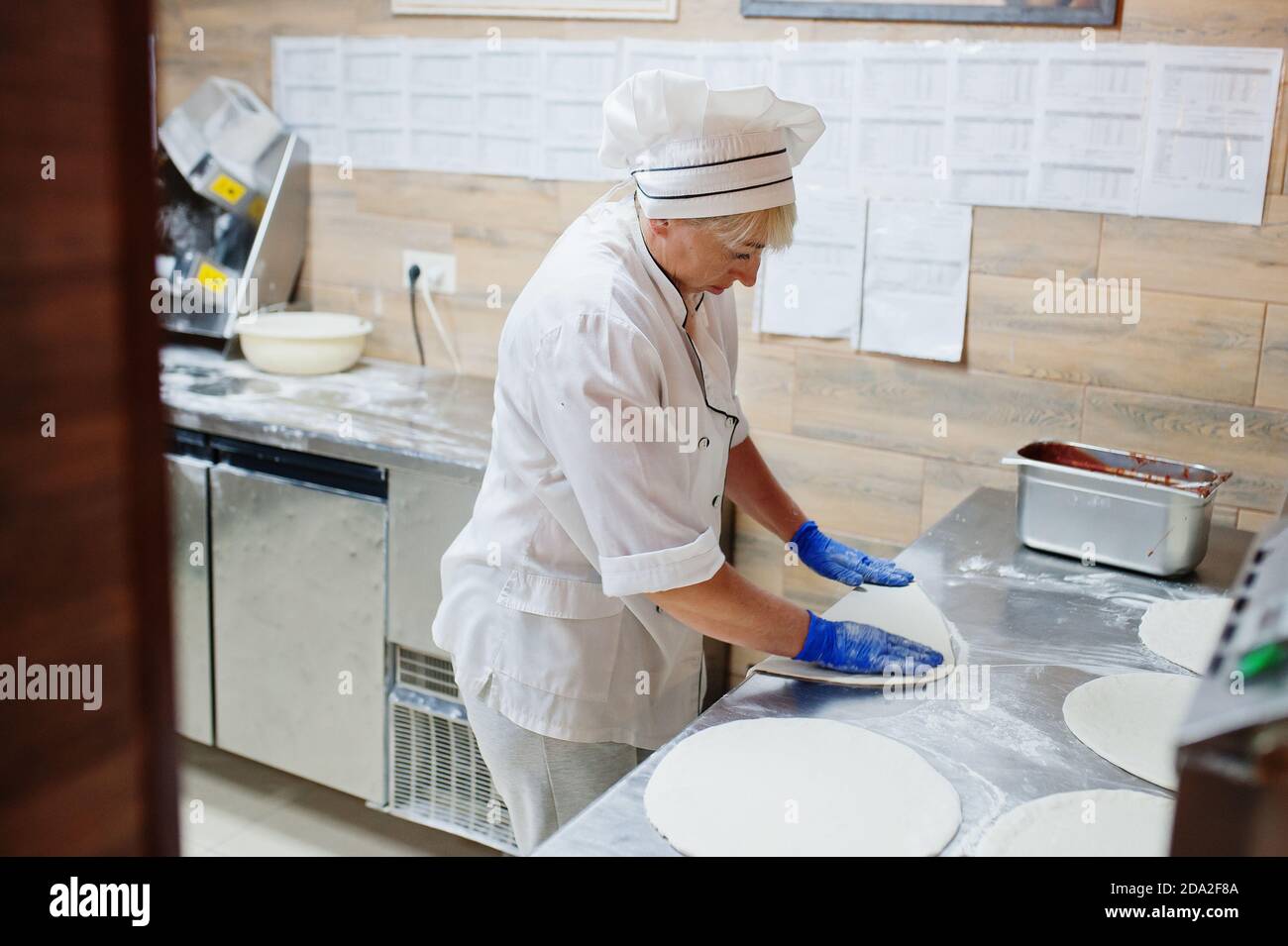 Female chef preparing pizza in restaurant kitchen Stock Photo - Alamy