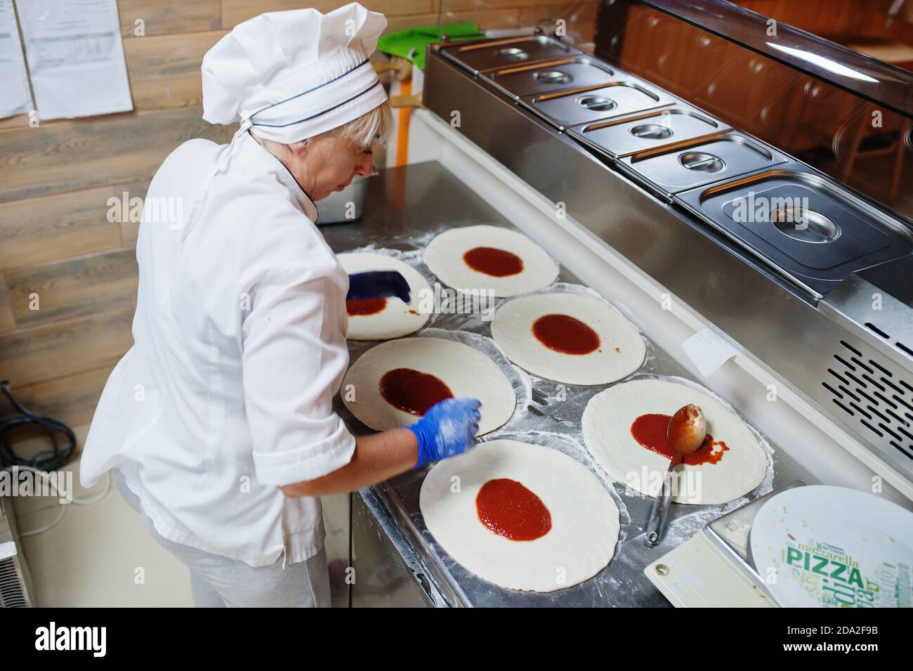 Female chef preparing pizza in restaurant kitchen Stock Photo - Alamy