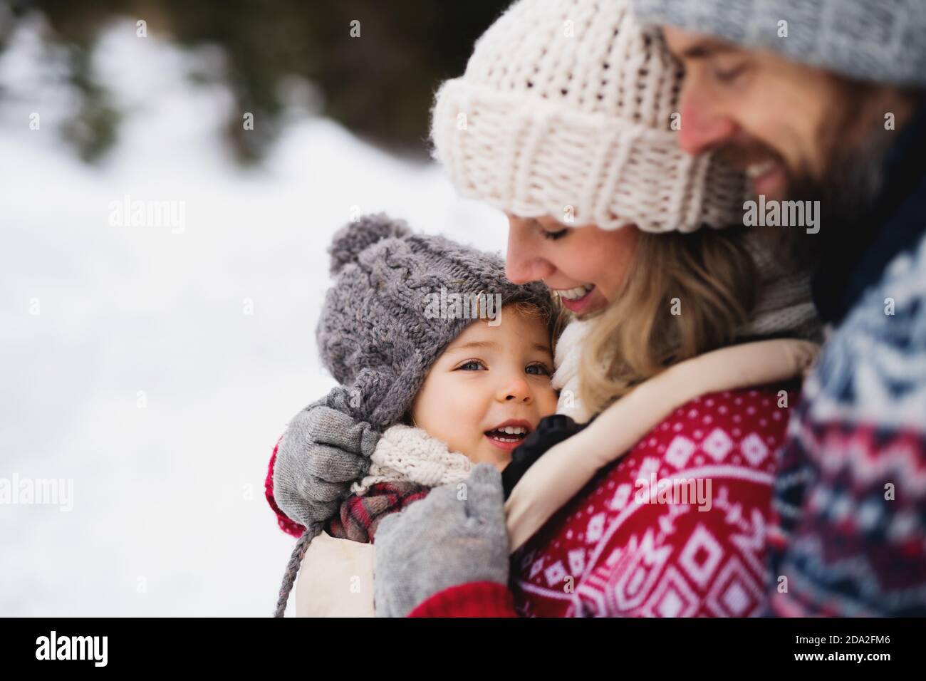 Side view of father and mother with small child in winter nature ...