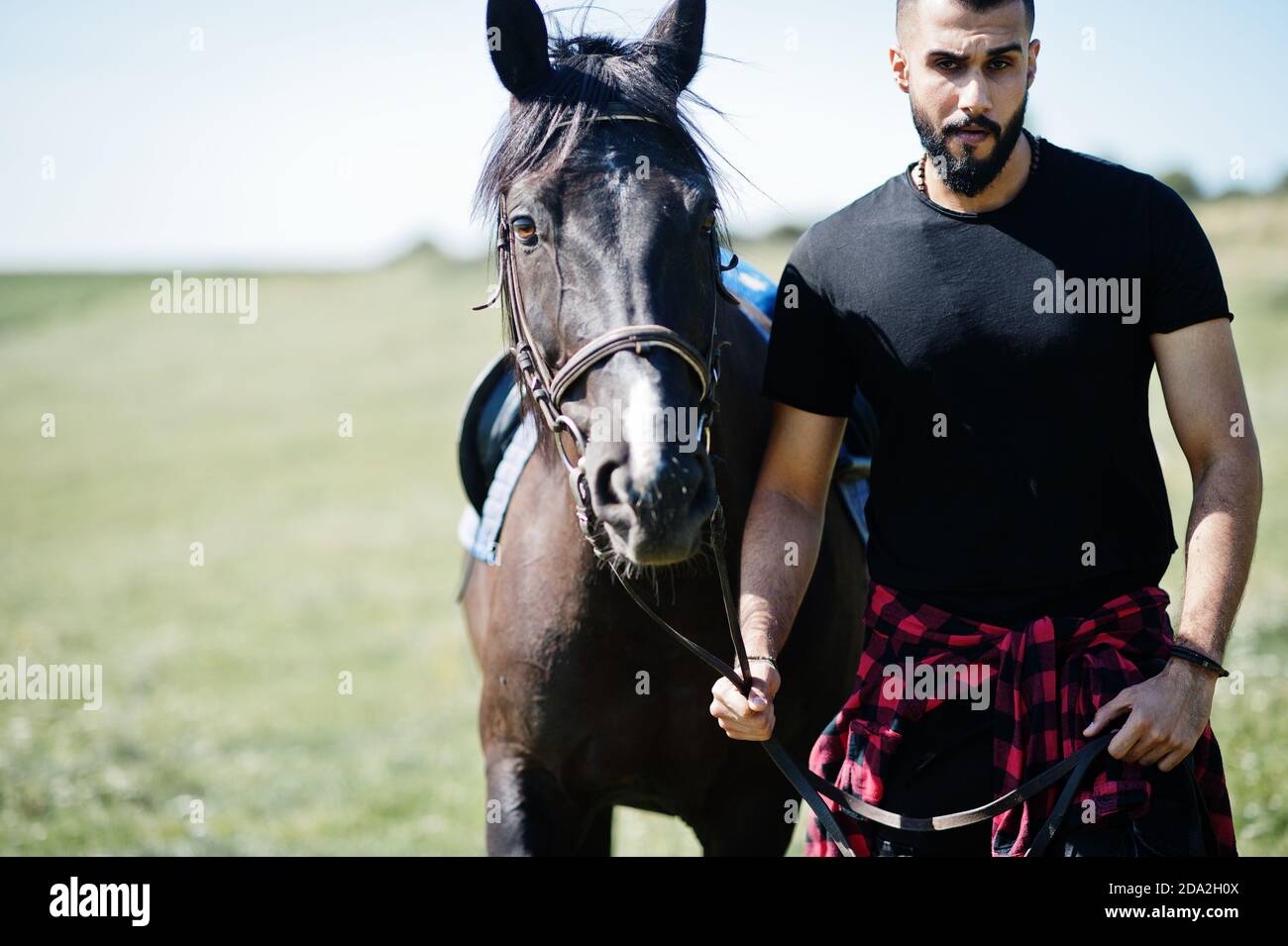 Arab tall beard man wear in black with arabian horse Stock Photo - Alamy
