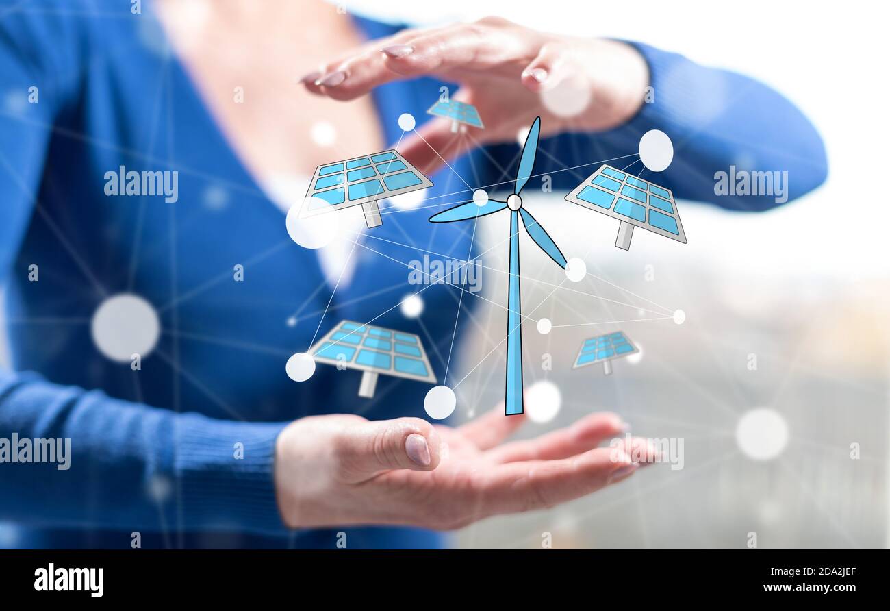 Green energy concept between hands of a woman in background Stock Photo ...