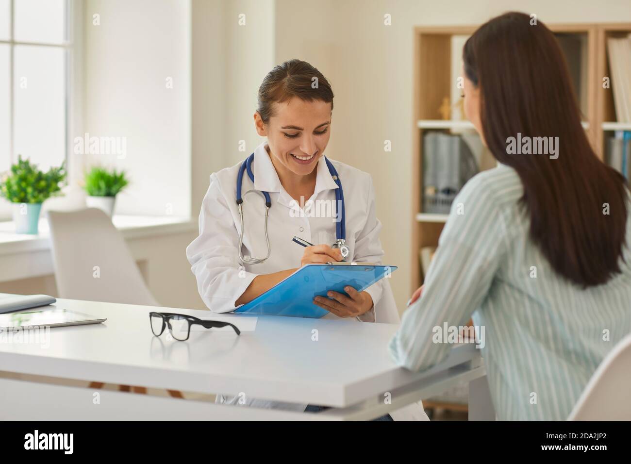 Doctor writing in patient chart hi-res stock photography and images - Alamy