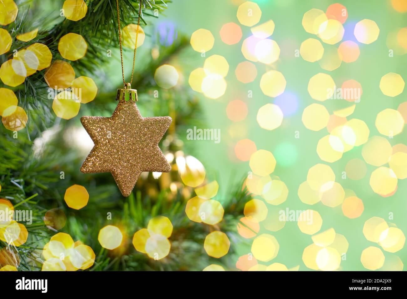 Christmas decoration golden twinkling star on a branch of a christmas ...